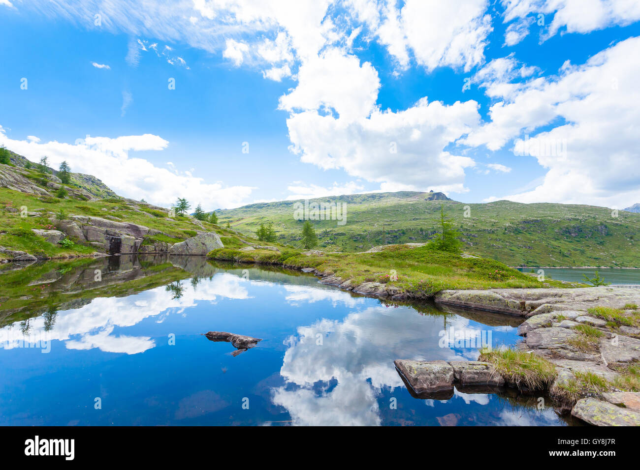 Italian mountain panorama, clouds reflected on alpine lake. Trekking ...
