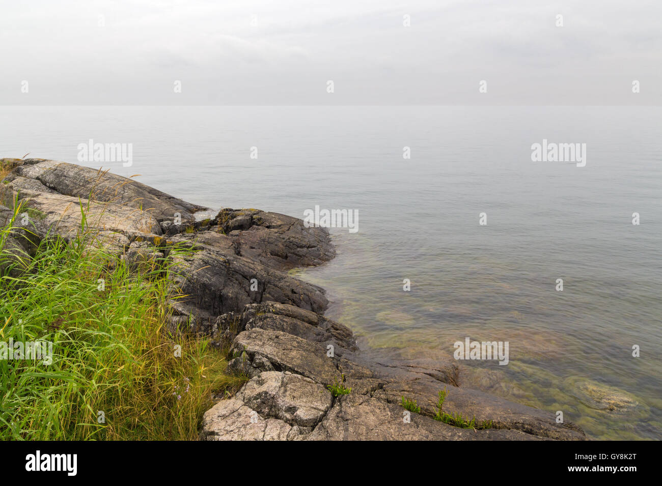 Rocky coast of a calm sea Stock Photo - Alamy