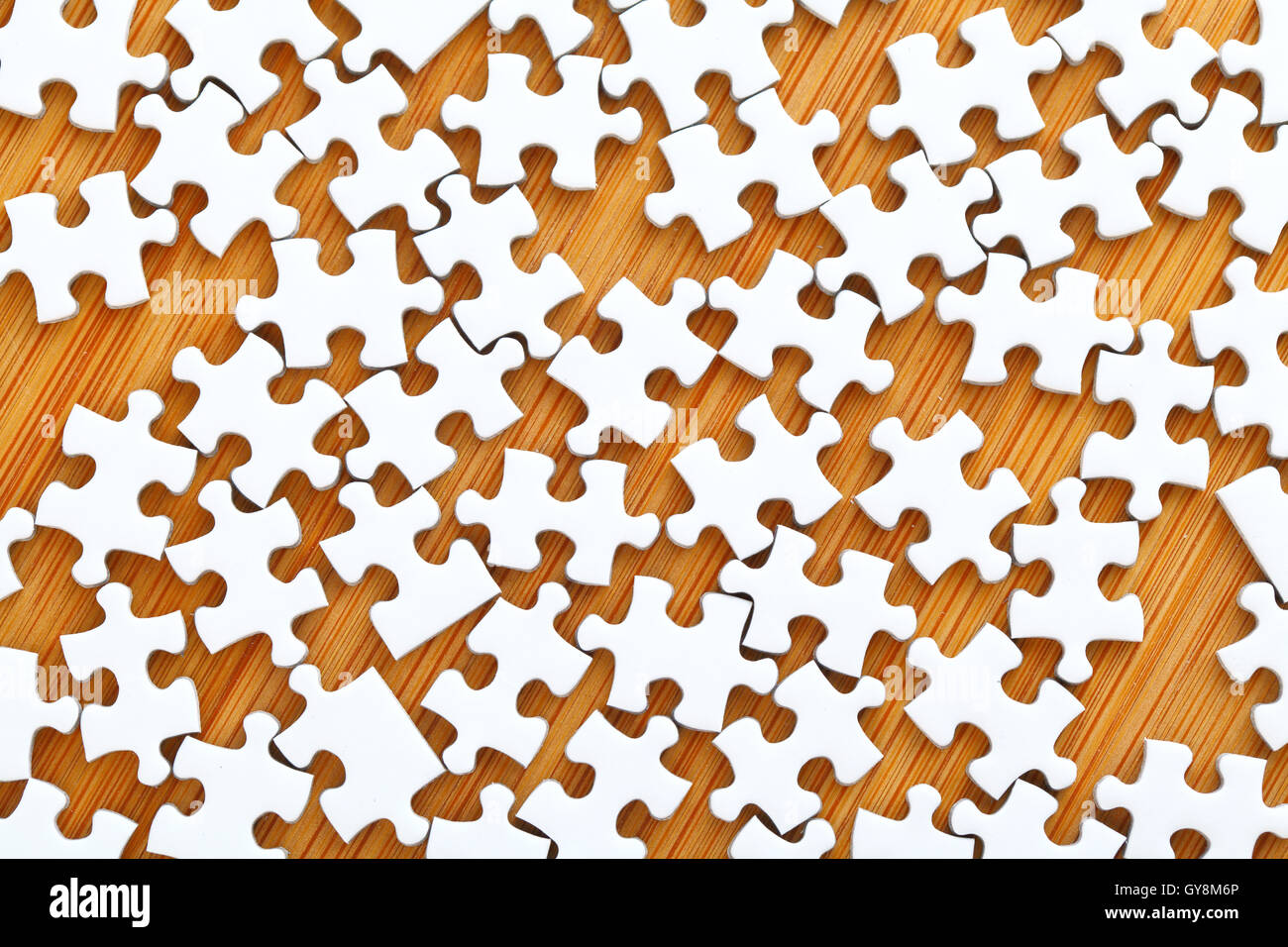 White puzzle on wooden background Stock Photo - Alamy