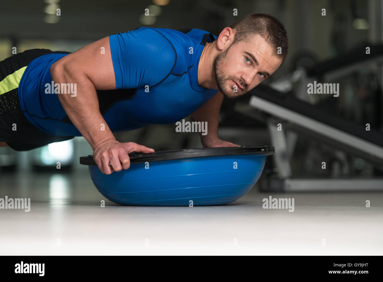 Personal Trainer Doing Pushups On Floor With Bosu Balance Ball As Part ...