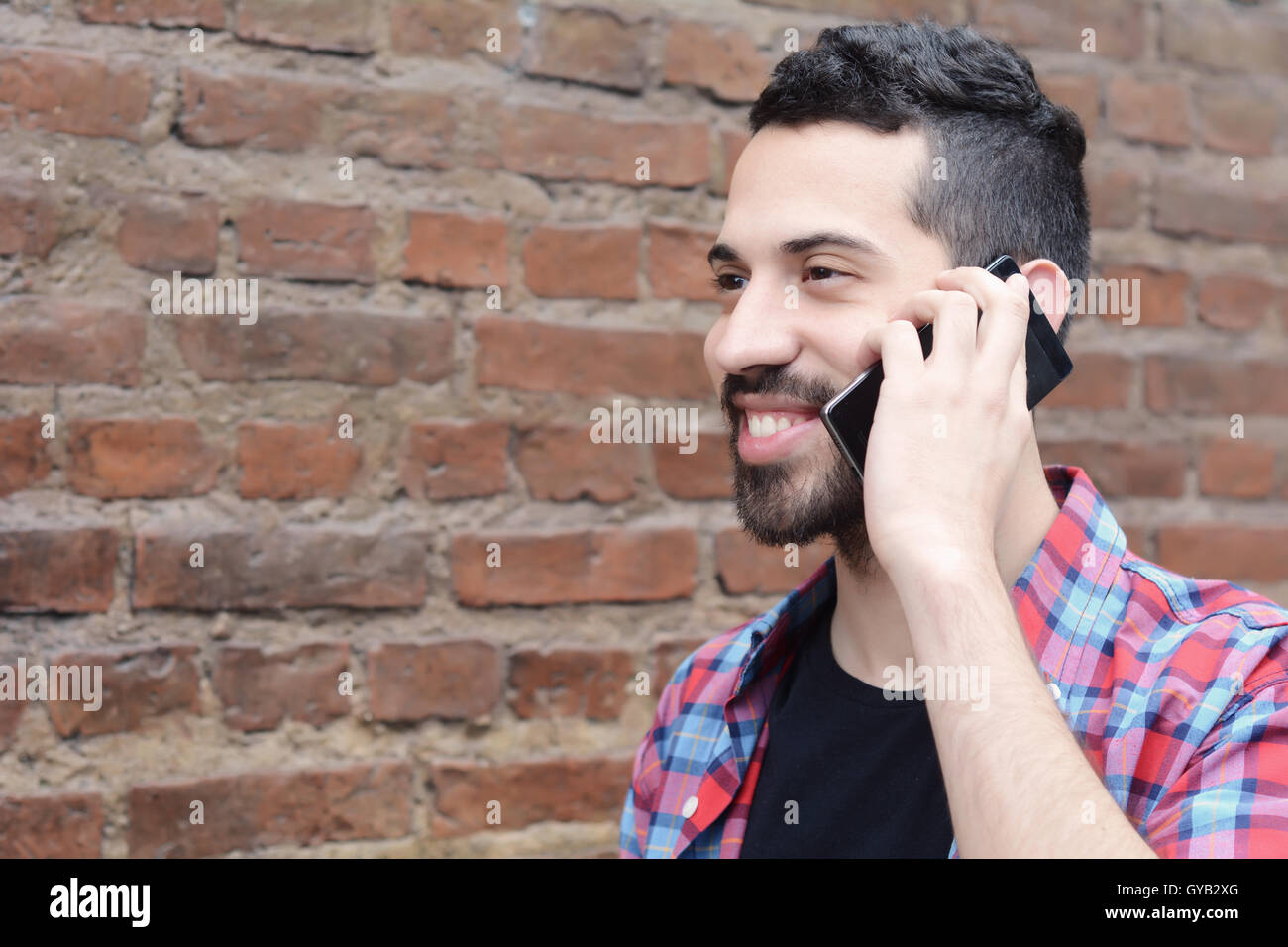 Handsome young man talking on the phone. Trendy and urban scene Stock ...