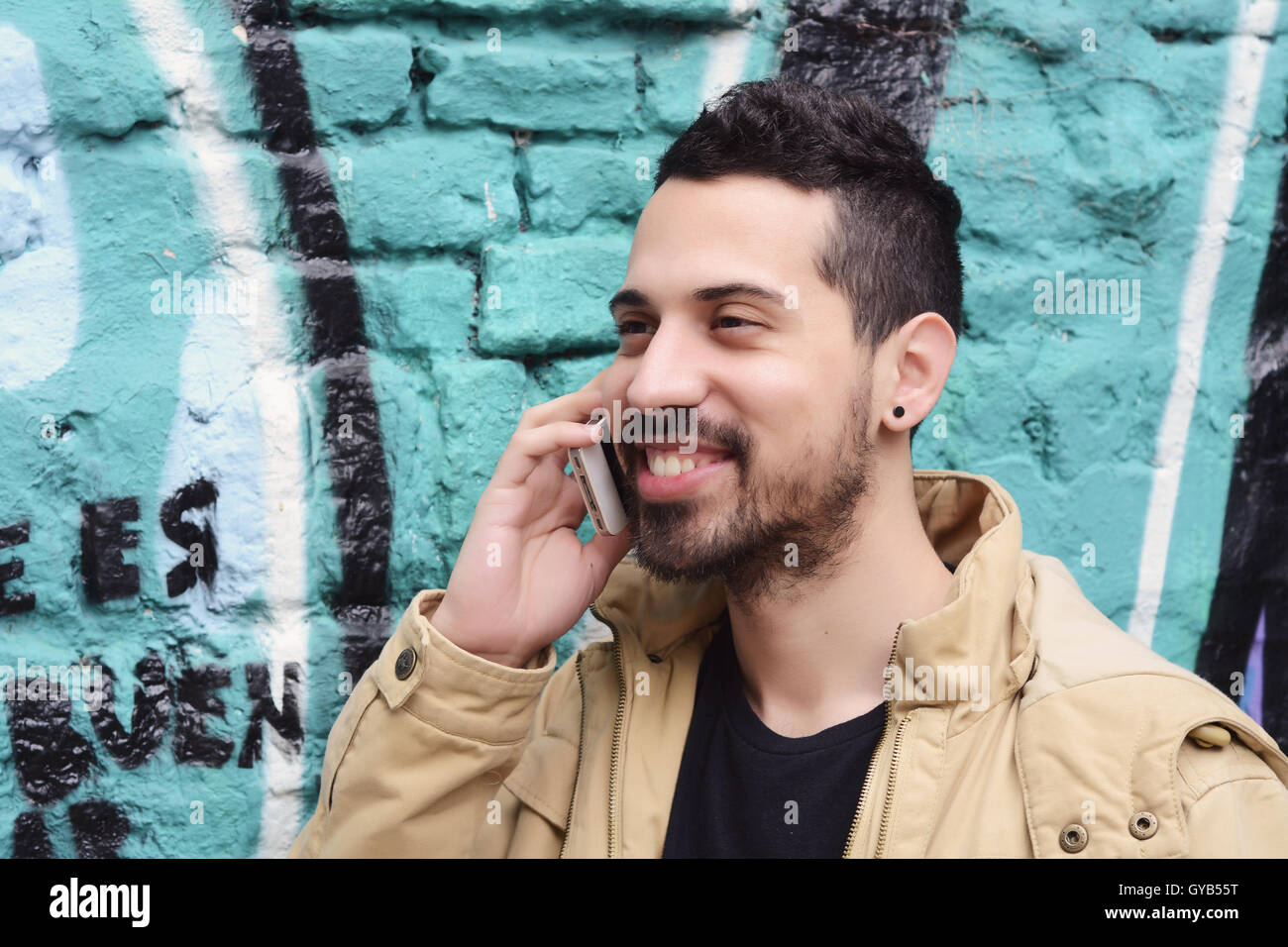 Handsome young man talking on the phone. Trendy and urban scene Stock ...