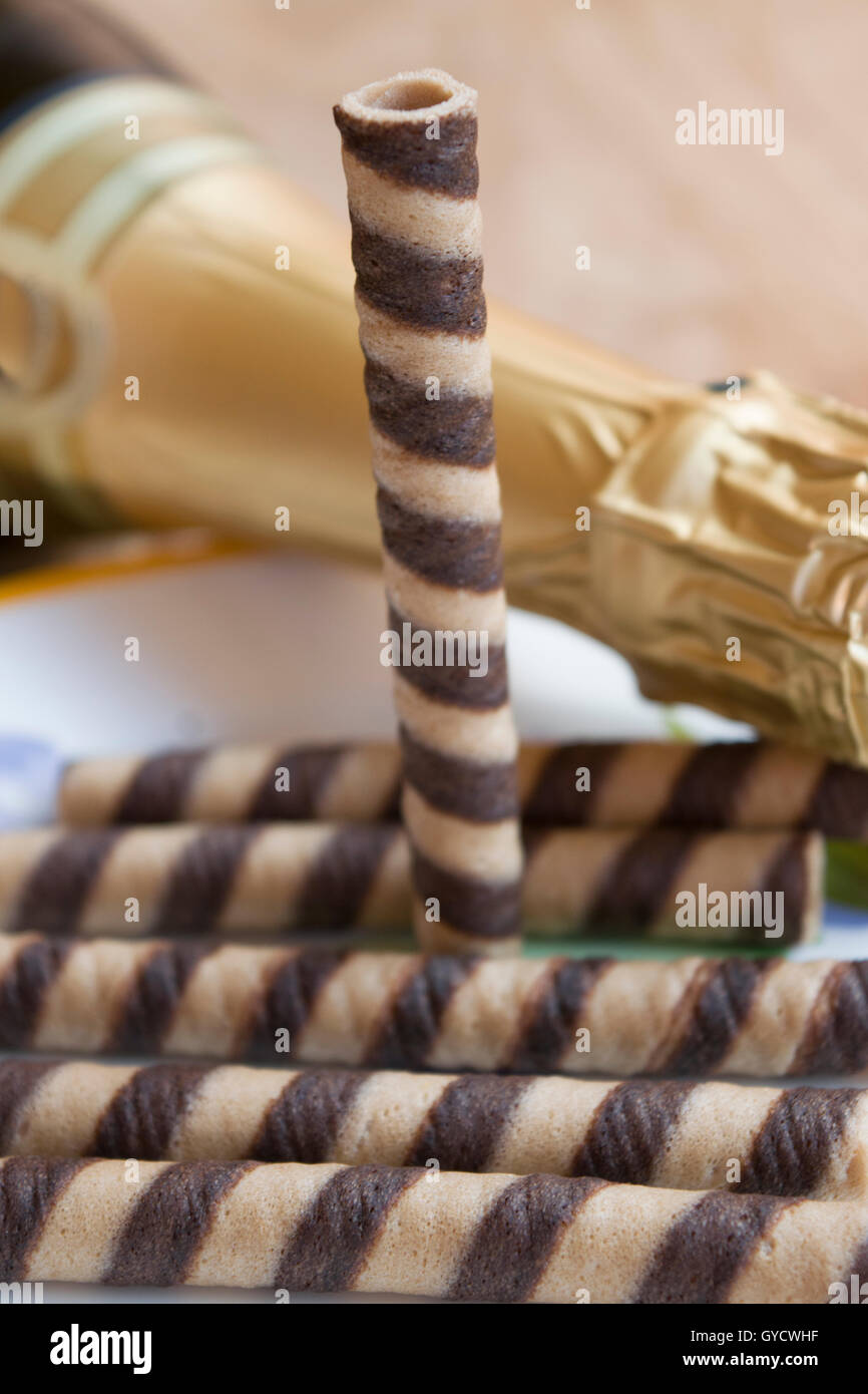 rolled wafers at the chocolate on a white dish and champagne bottle ...