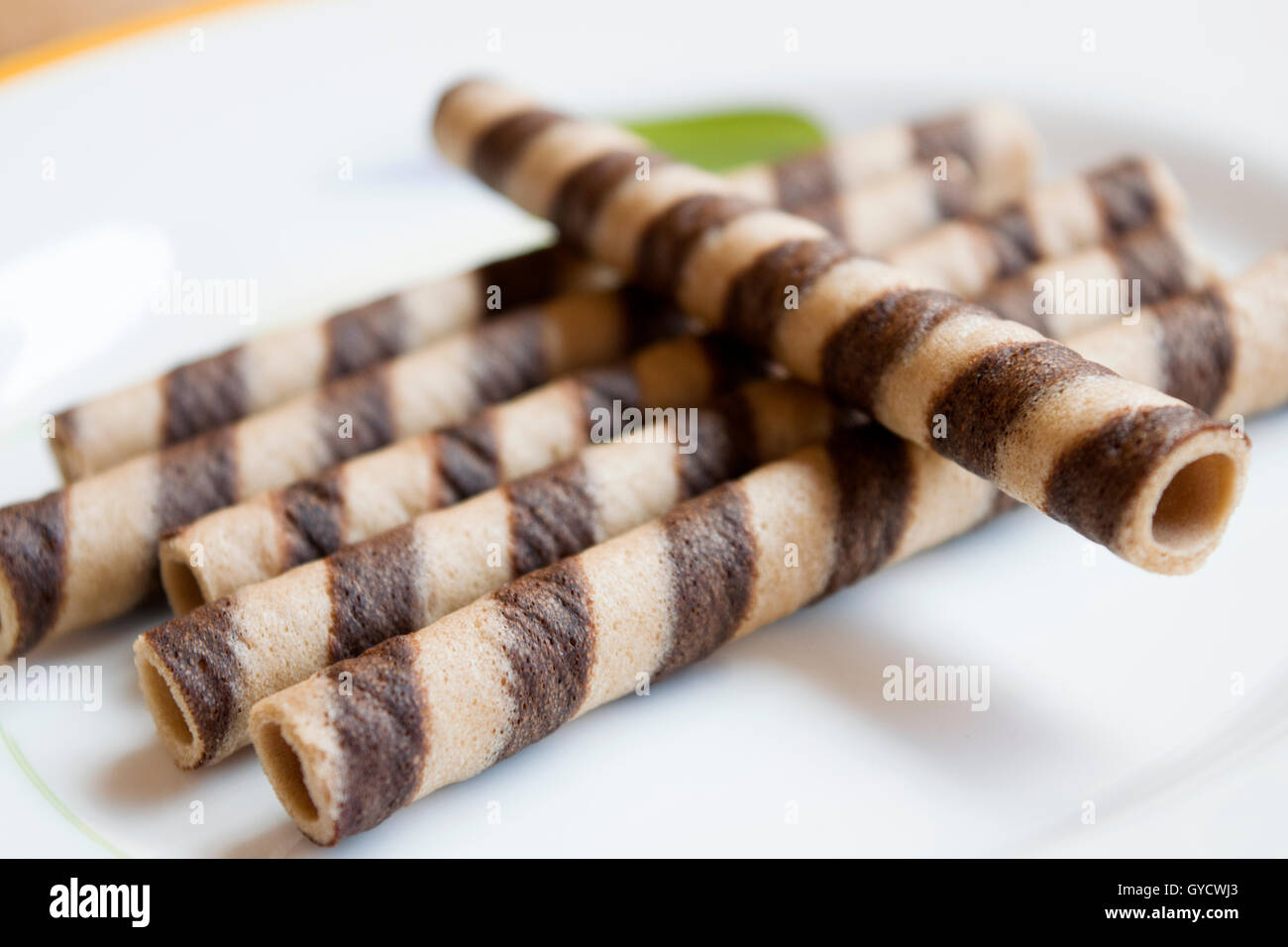 rolled wafers at the chocolate on a white dish Stock Photo - Alamy