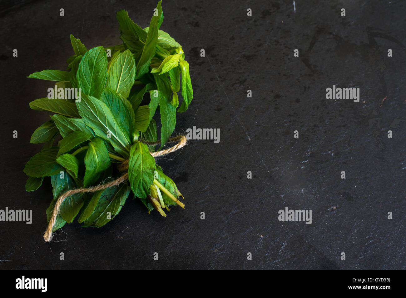 Fresh mint with rope on rustic background Stock Photo - Alamy