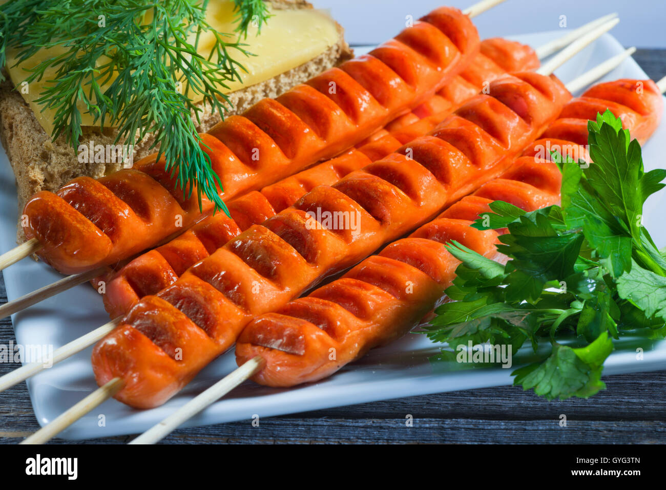 The sausages made on a grill and greens rectangular plate Stock Photo ...