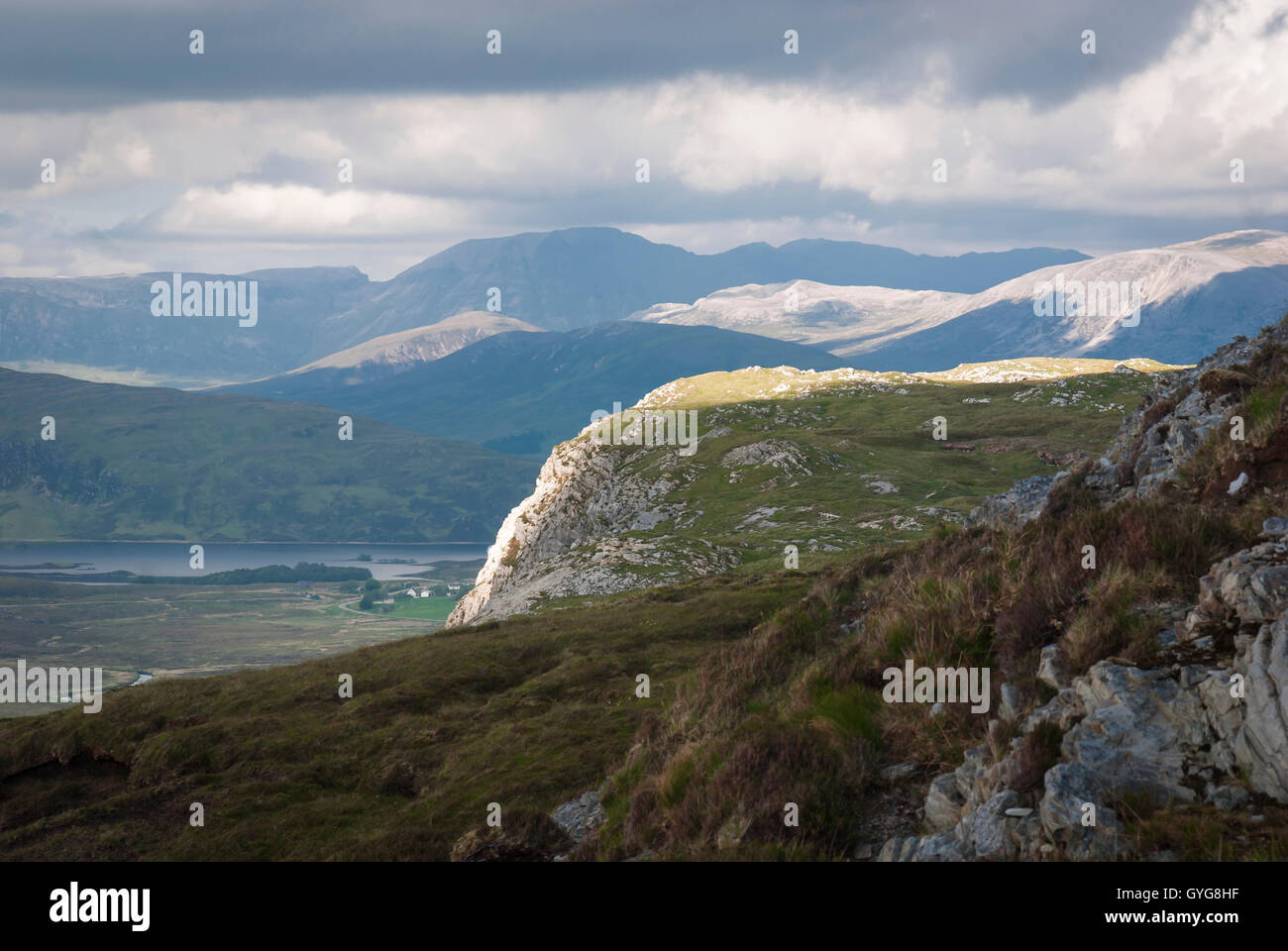 Sunlight catching Knockan Crag with the Sutherland Mountains in the ...