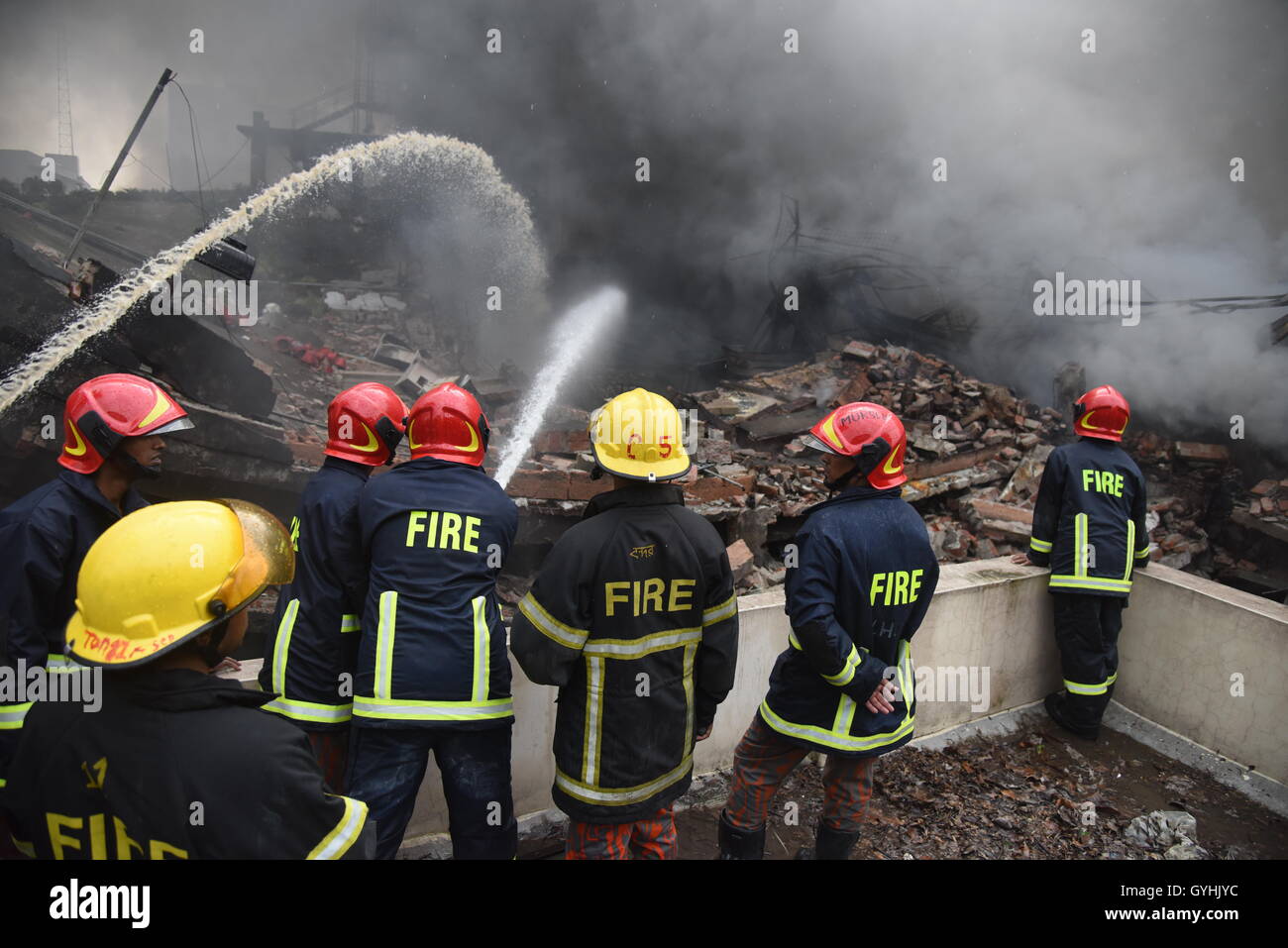 Firefighters work to put out a fire at a Tampaco packaging factory in ...