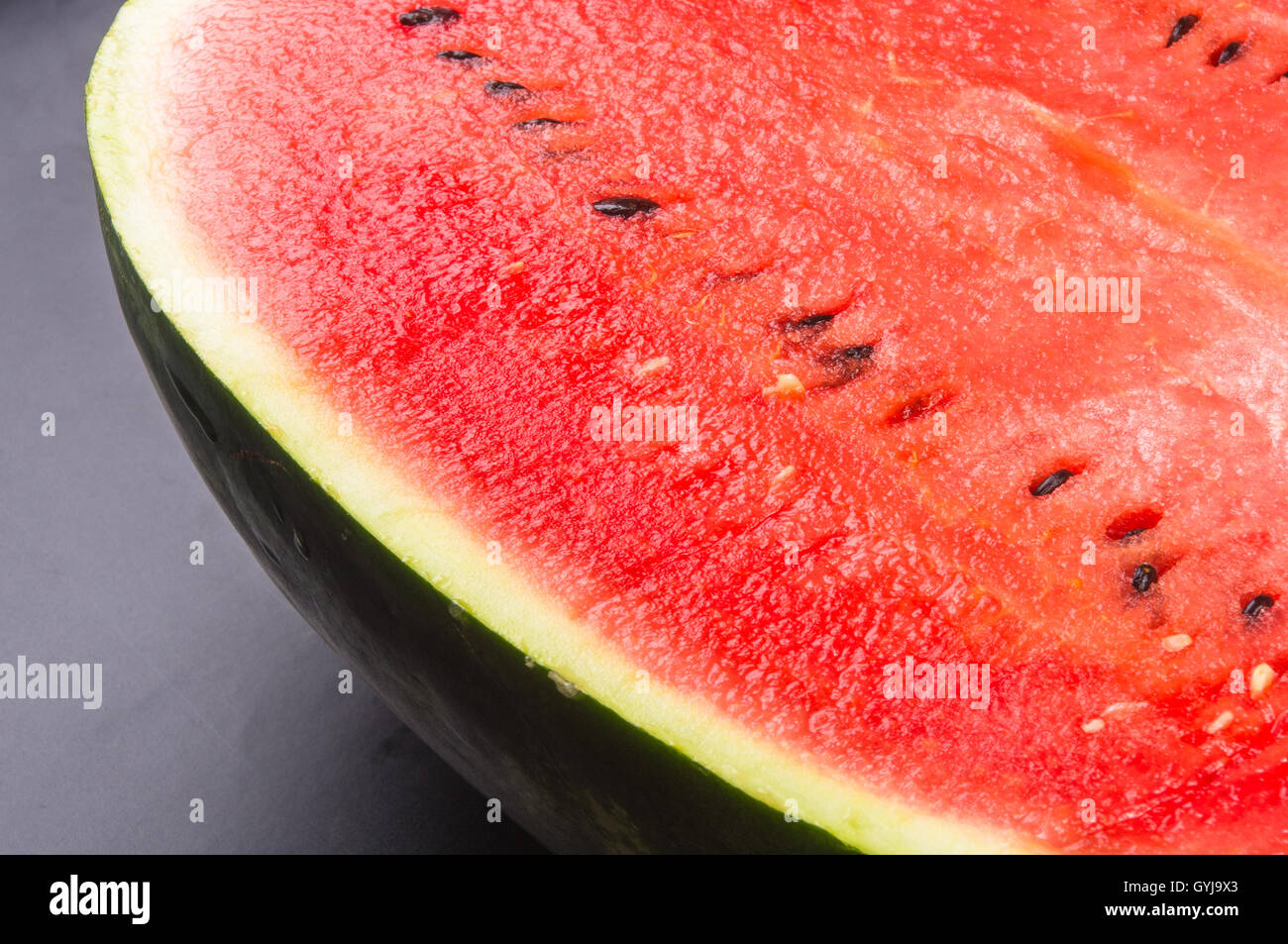 half of ripe watermelon on a black background Stock Photo - Alamy