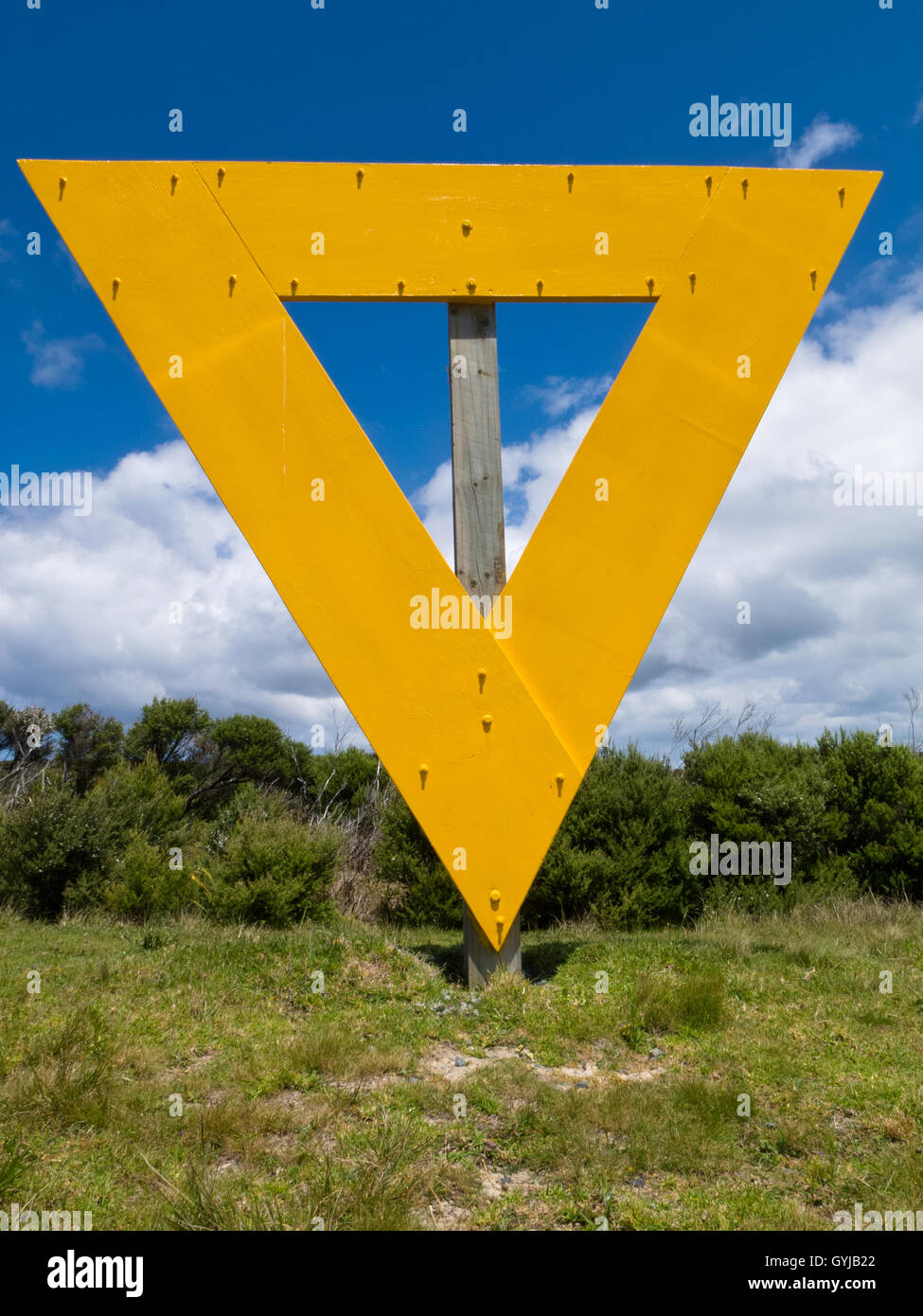 Shipping navigation yellow triangle sign on land Stock Photo - Alamy