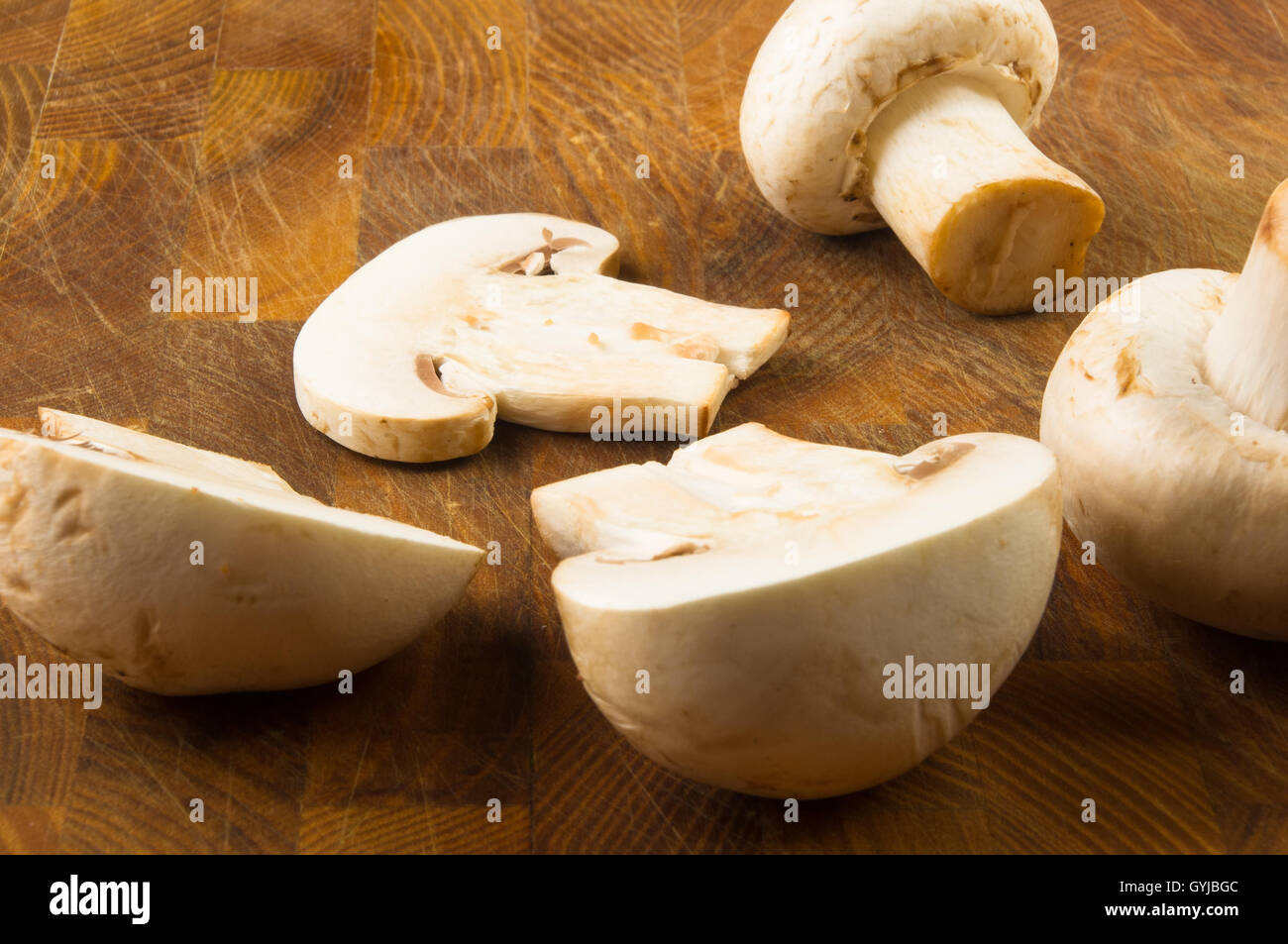 whole and cut scattered mushrooms champignons on wooden background ...