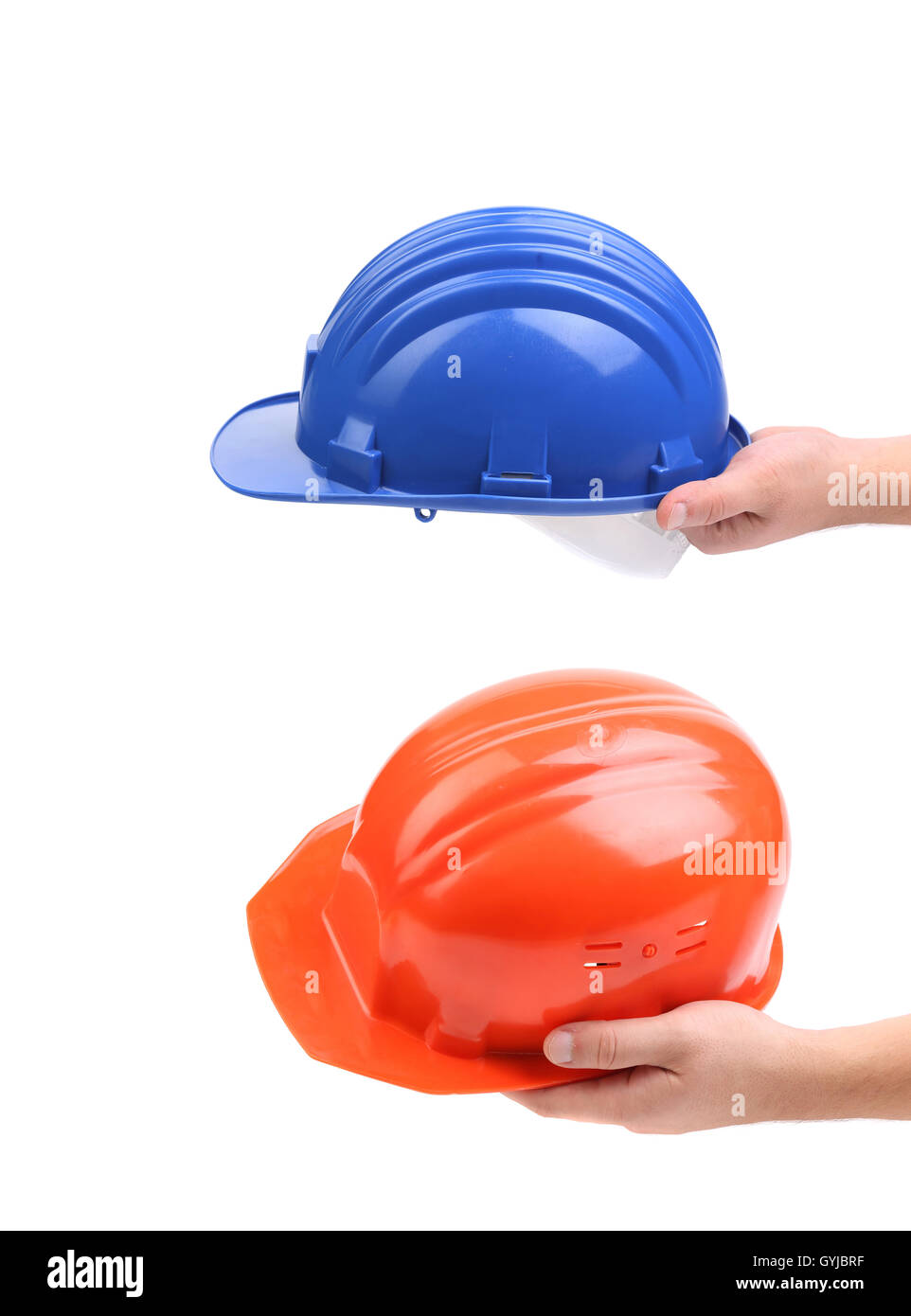 Two hands holding hard hats Stock Photo - Alamy