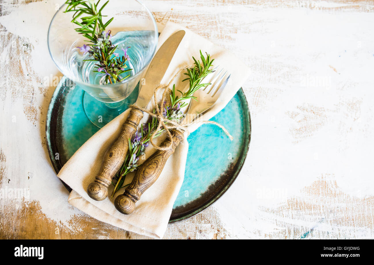 Summer time table setting with fresh rosemary spice on rustic ...