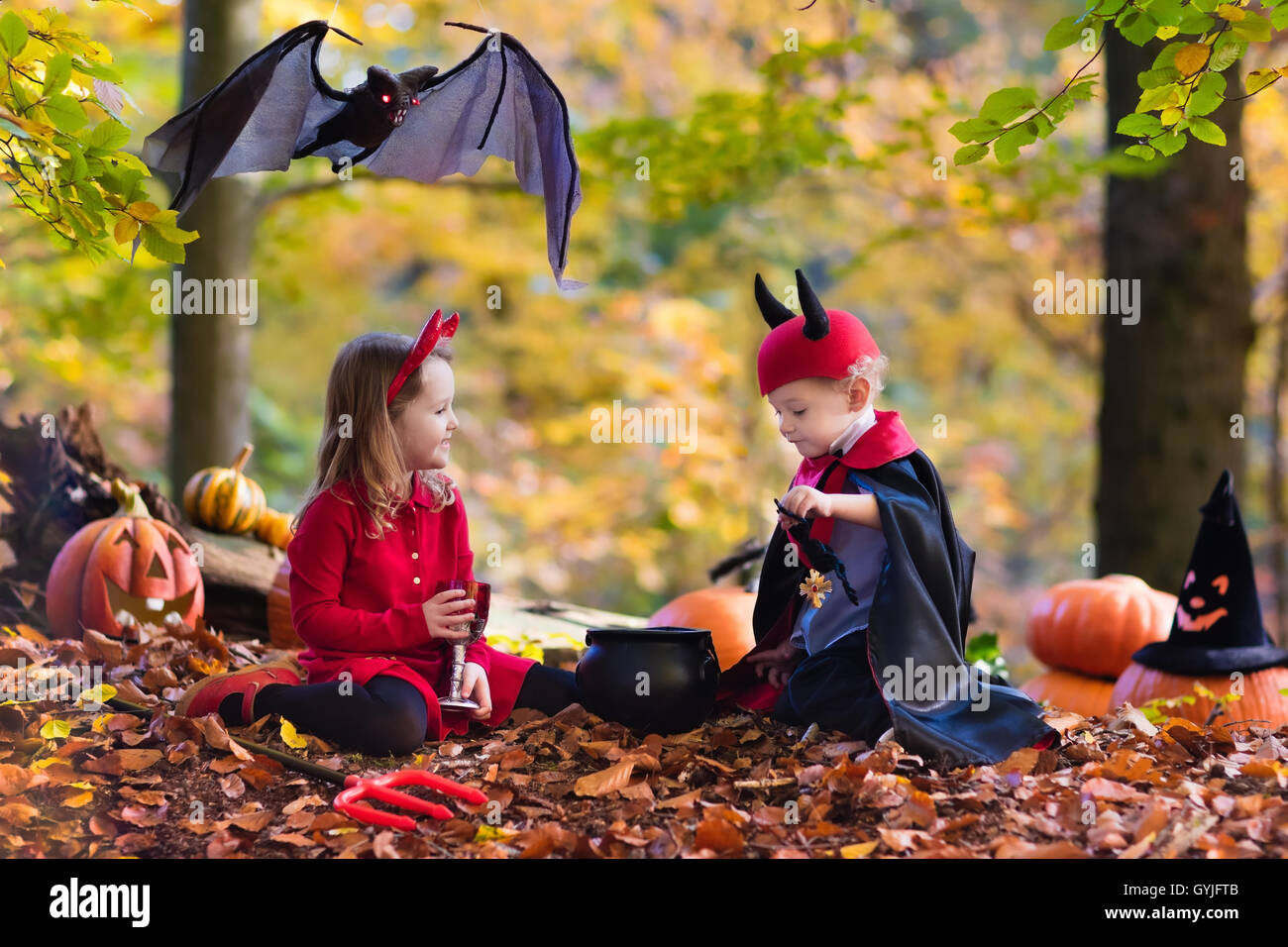 Two funny kids wearing devil and vampire costume with red horns and ...