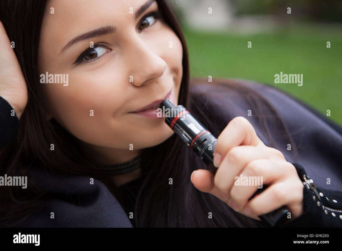 Happy vaping young white brunette girl.Smiling female model smoking ...
