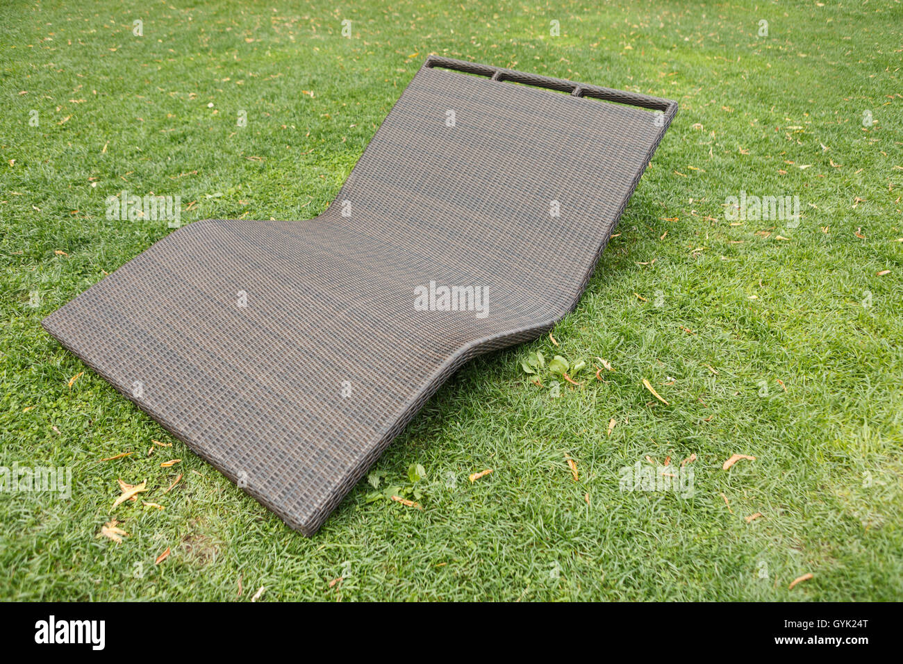 Long dark brown recliner daybed on green grass. Comfortable lounge bed ...