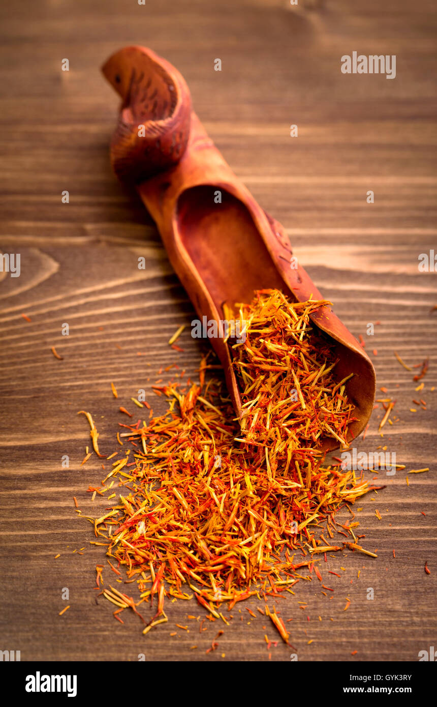Saffron spice threads in scoop on wooden background Stock Photo - Alamy