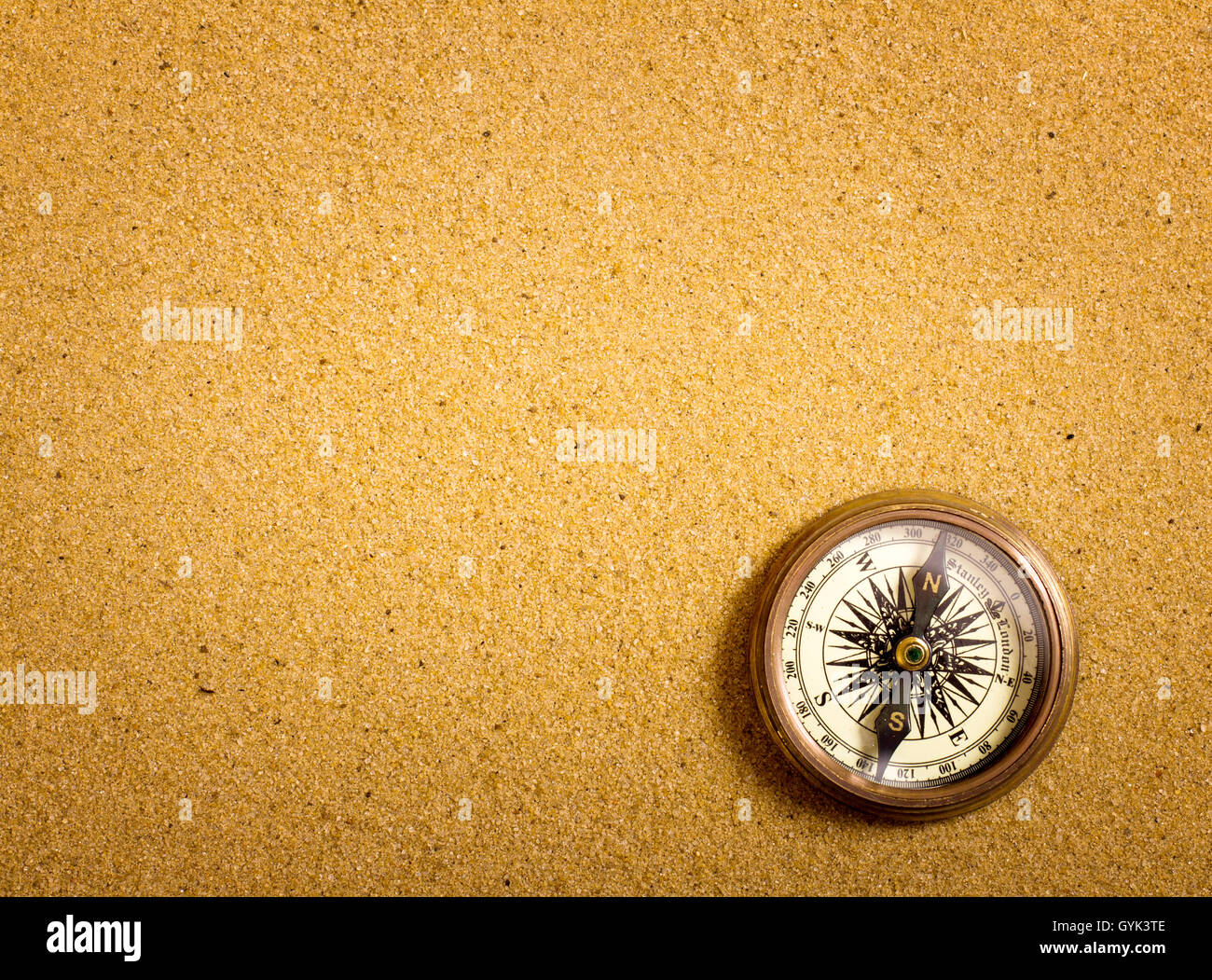 Compass on sand background Stock Photo - Alamy