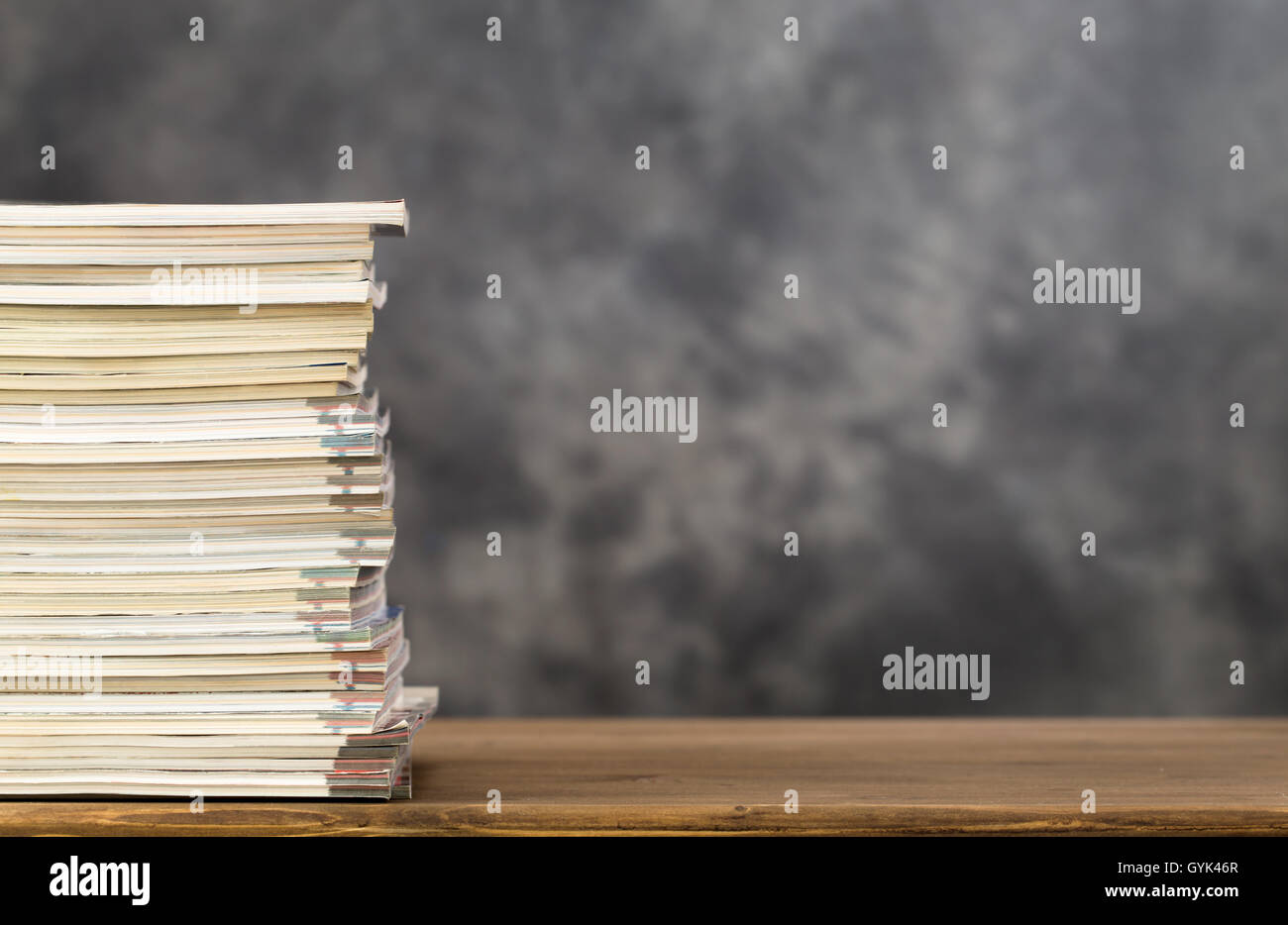 Stack of magazines on left side of table Stock Photo - Alamy