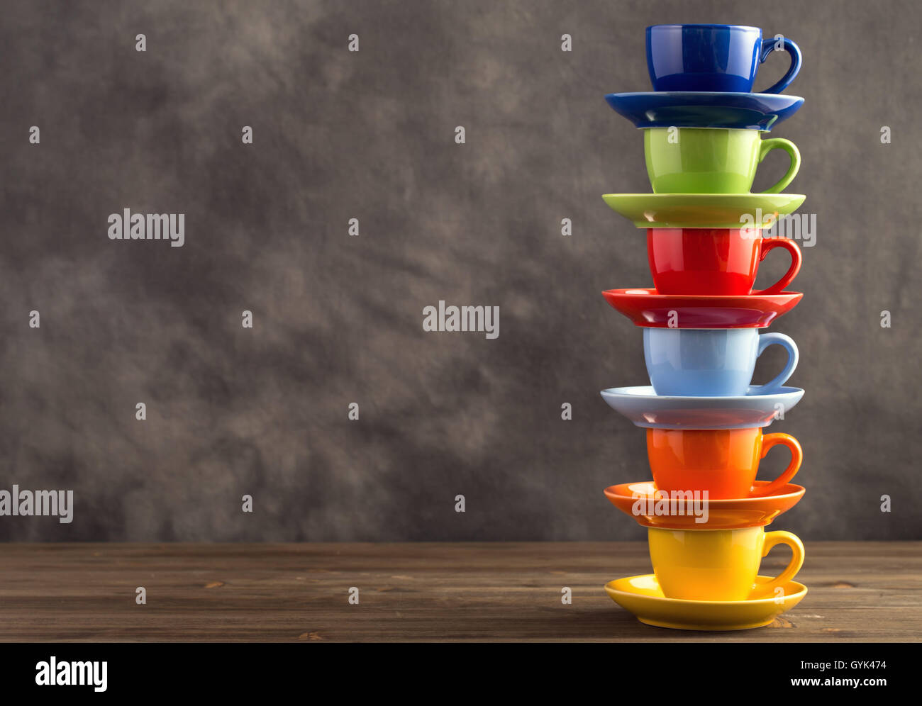 Stack of six multicolored cups on table from right side Stock Photo - Alamy