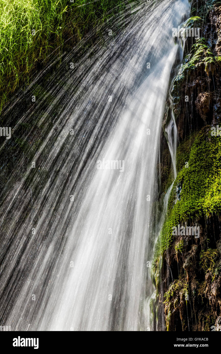 Movement blurred water falling over the moss of a waterfall. Vertical ...