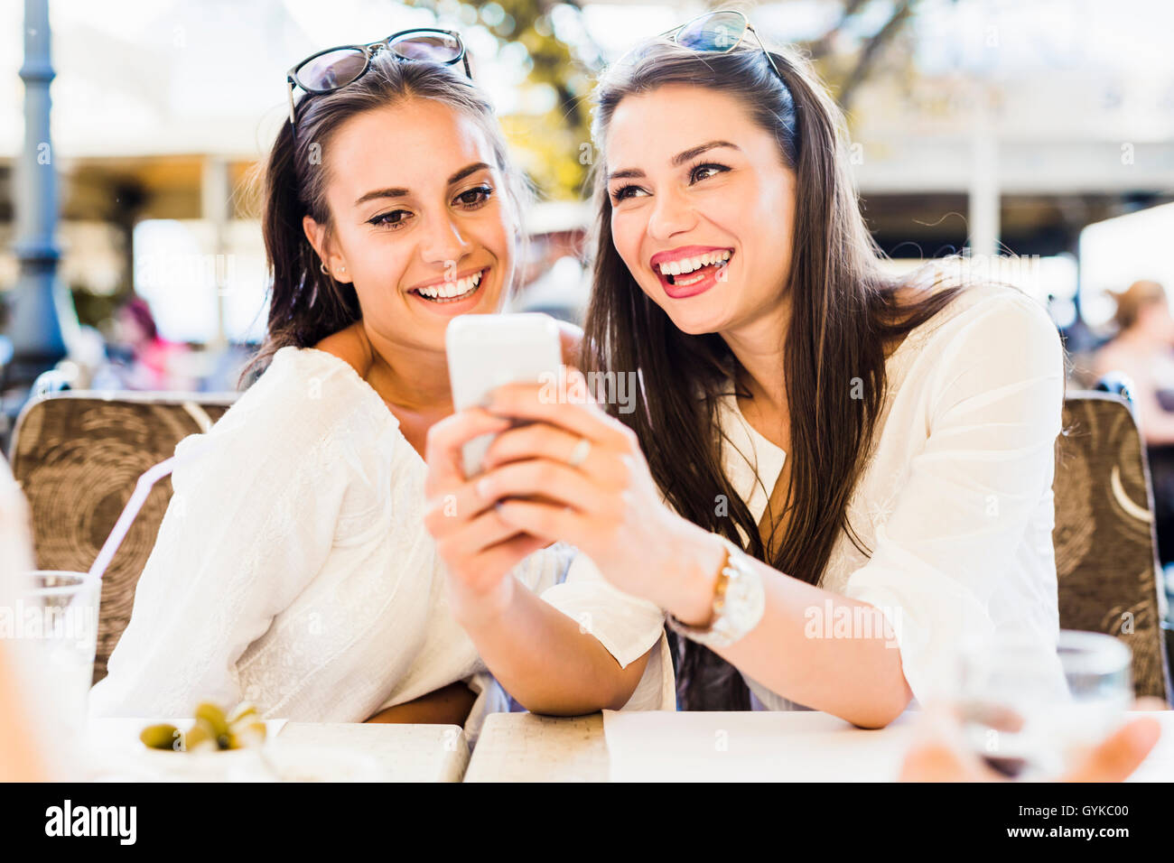Two young girls talking and smiling during lunch break Stock Photo - Alamy
