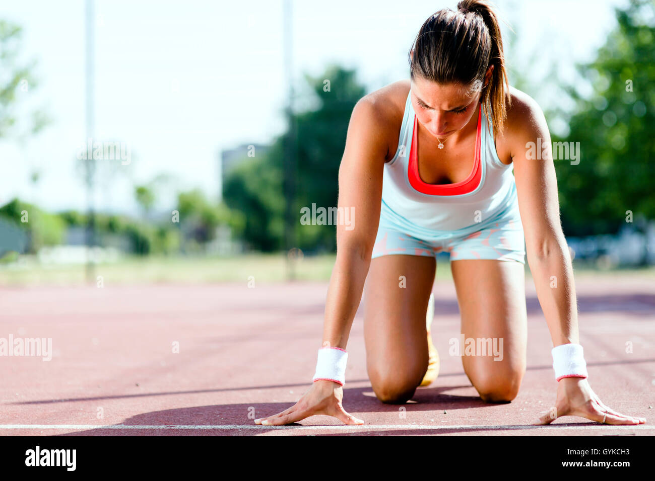 Beautiful female sprinter getting ready for the run during summer Stock ...