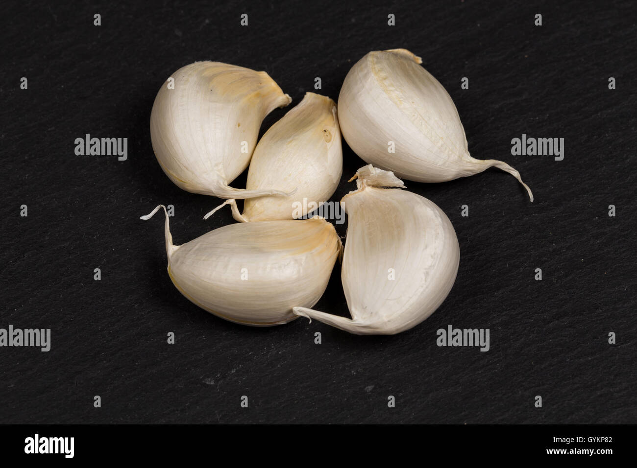 still life photo of organic whole garlic on black stone plate Stock ...