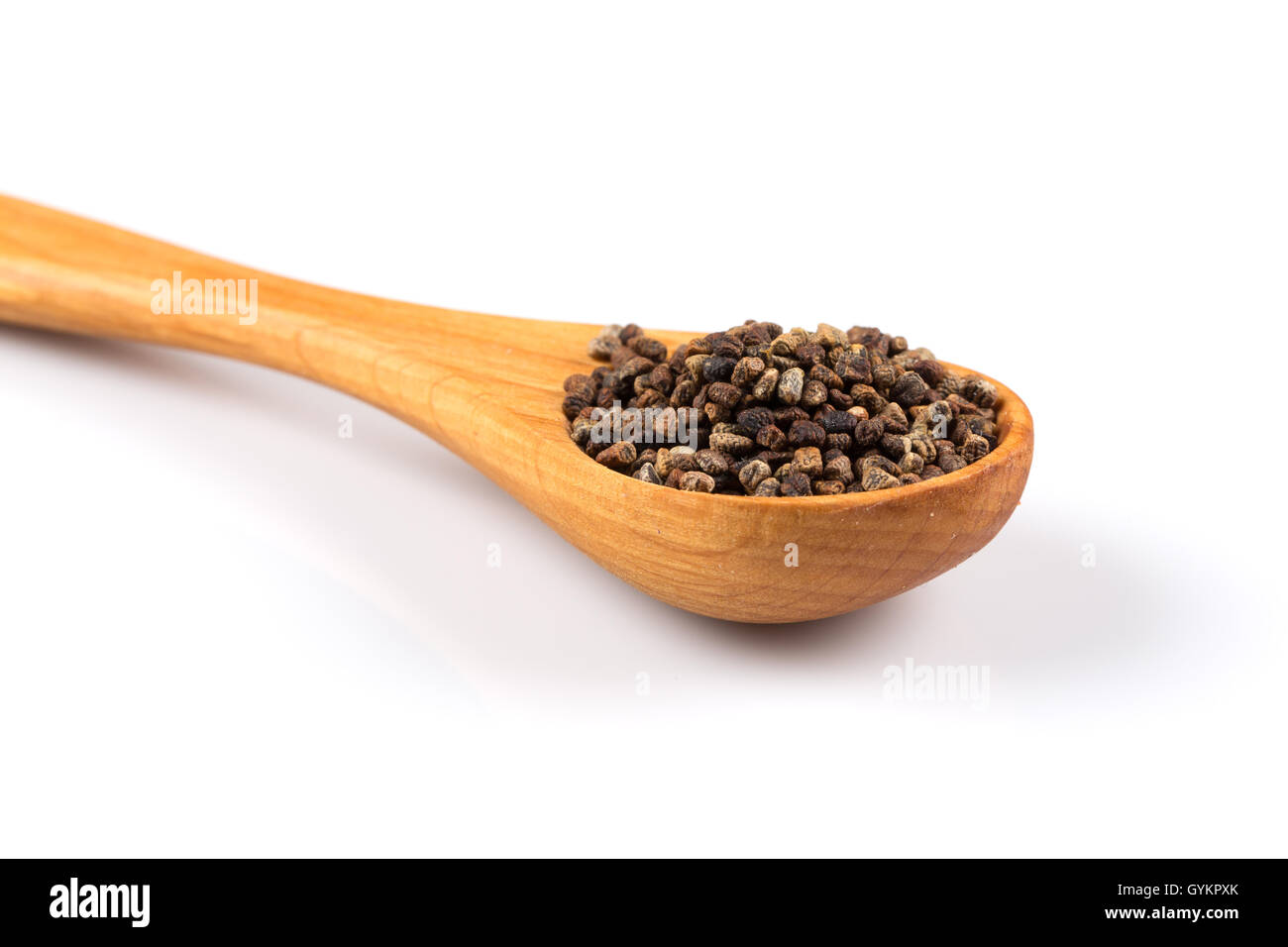 Decorticated cardamom seeds in a wooden spoon on white background Stock ...