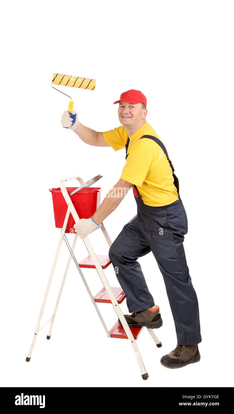 Worker on ladder with roller and bucket Stock Photo - Alamy