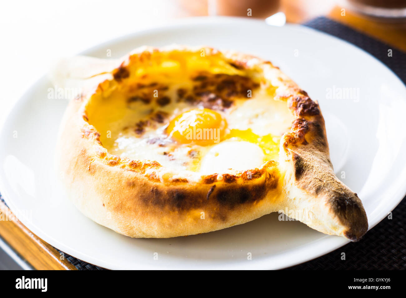 Ajarian or Adjaruli khachapuri, filled with cheese and topped with a ...
