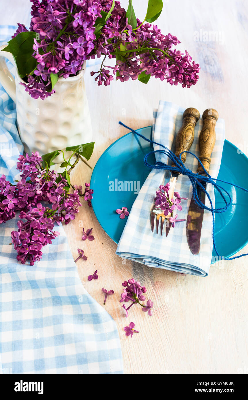 Spring time table setting with lilac flowers and vintage plates and ...