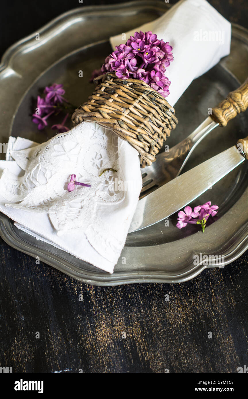 Spring time table setting with lilac flowers and vintage plates and ...