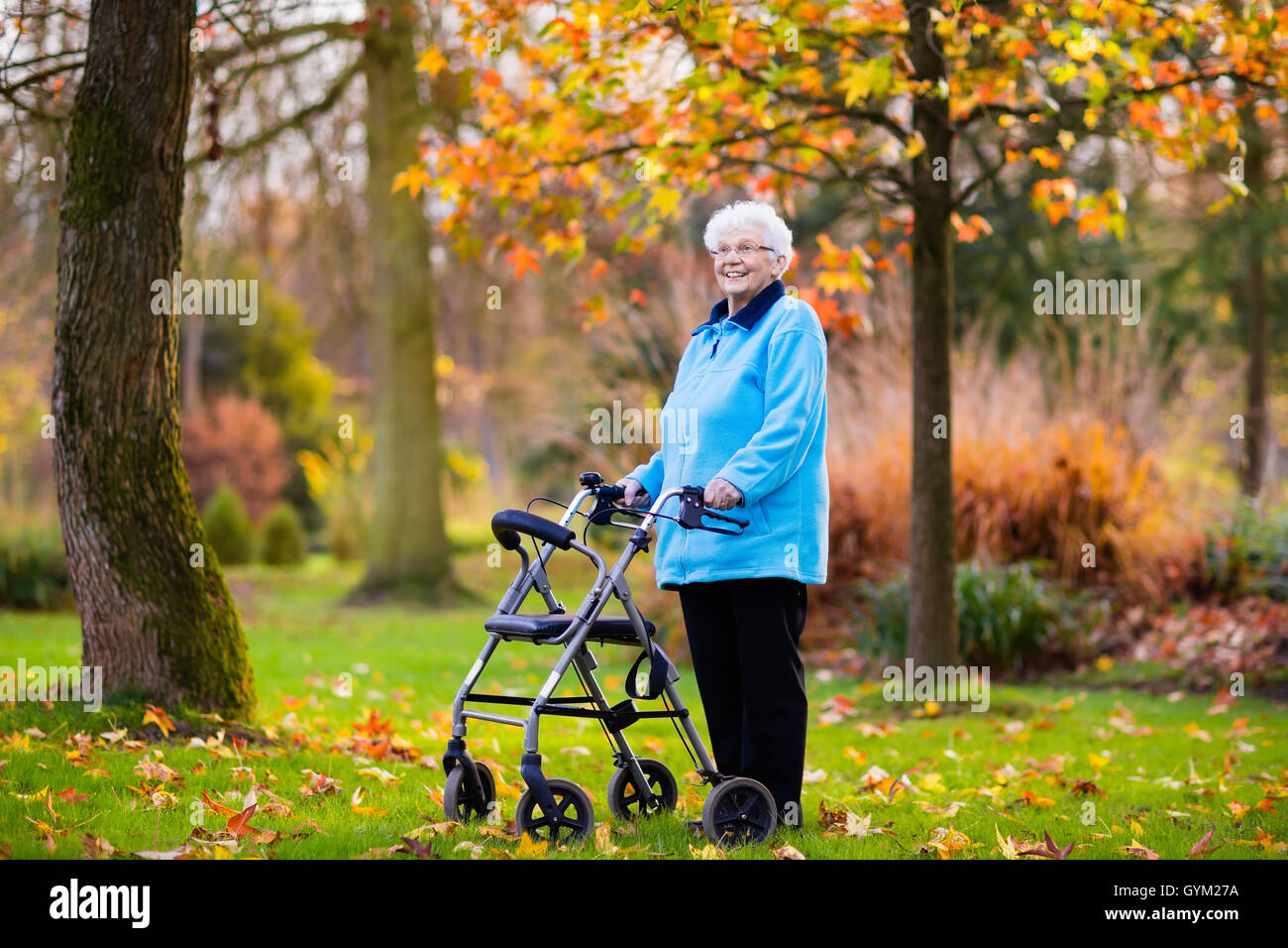 Happy senior handicapped lady with a walking disability enjoying a walk ...