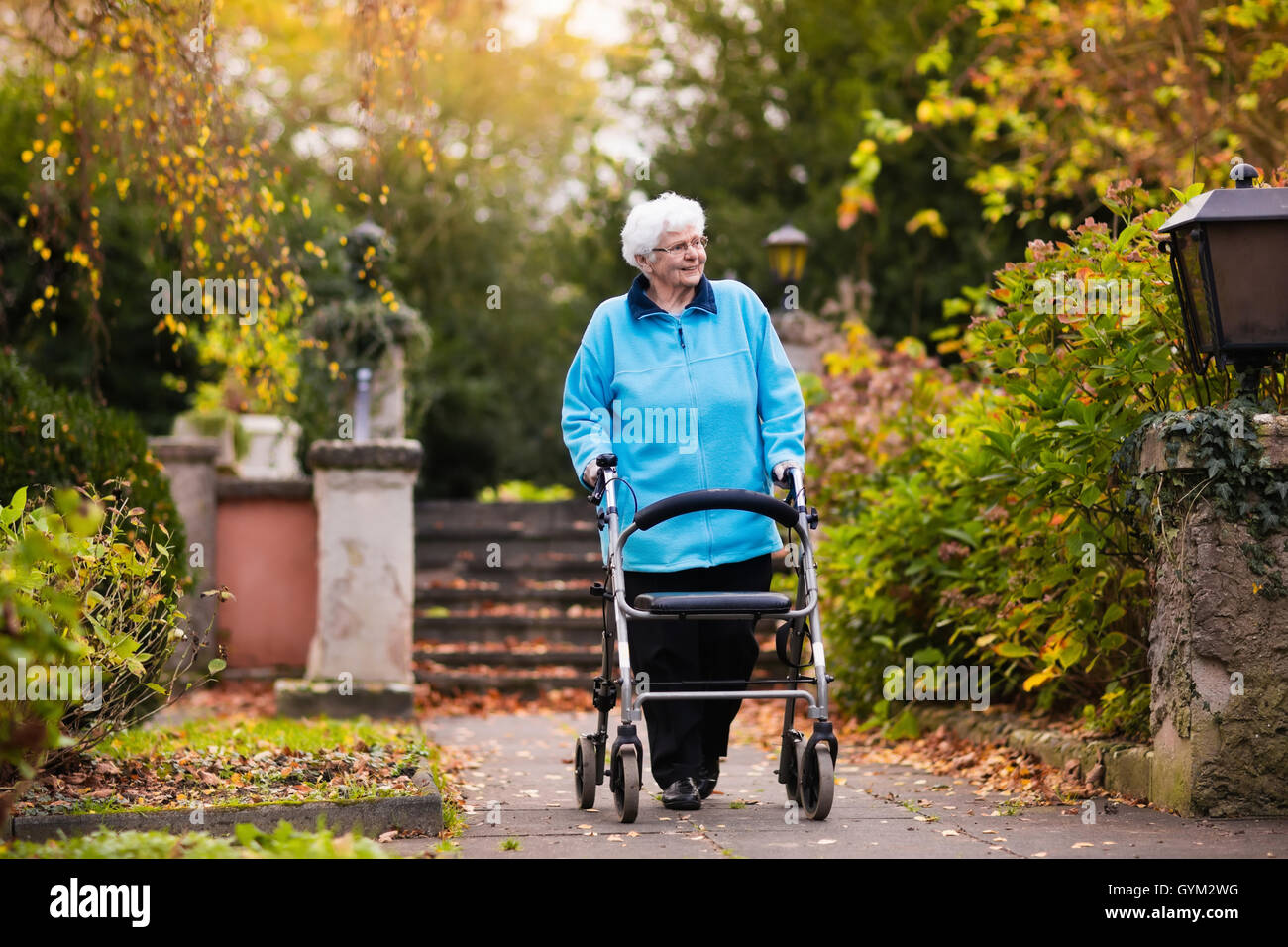 Happy senior handicapped lady with a walking disability enjoying a walk ...