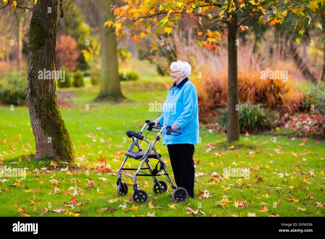 Happy senior handicapped lady with a walking disability enjoying a walk ...