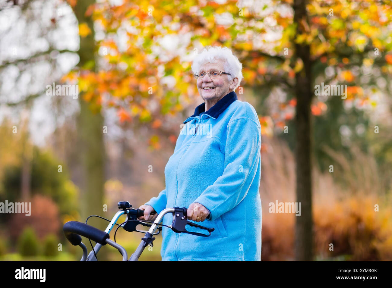 Happy senior handicapped lady with a walking disability enjoying a walk ...