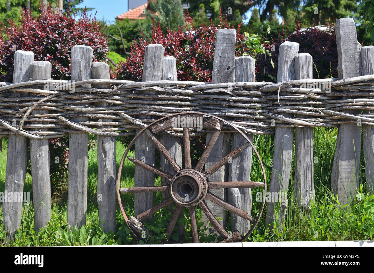 Old wheel of a traditional cart leaning on a wooden fence Stock Photo ...