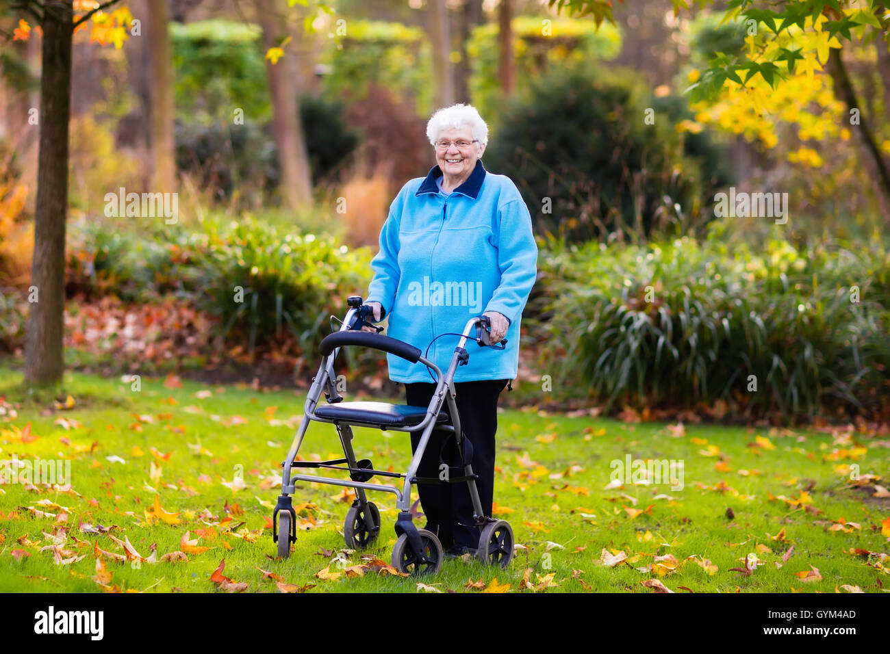 Happy senior handicapped lady with a walking disability enjoying a walk ...