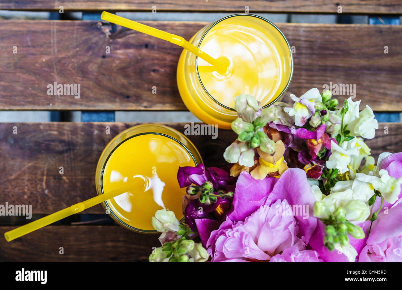 Orange juice and summer flowers on the table Stock Photo - Alamy