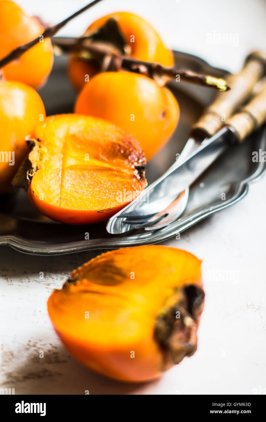 Ripe persimmons fruits on rustic background Stock Photo - Alamy