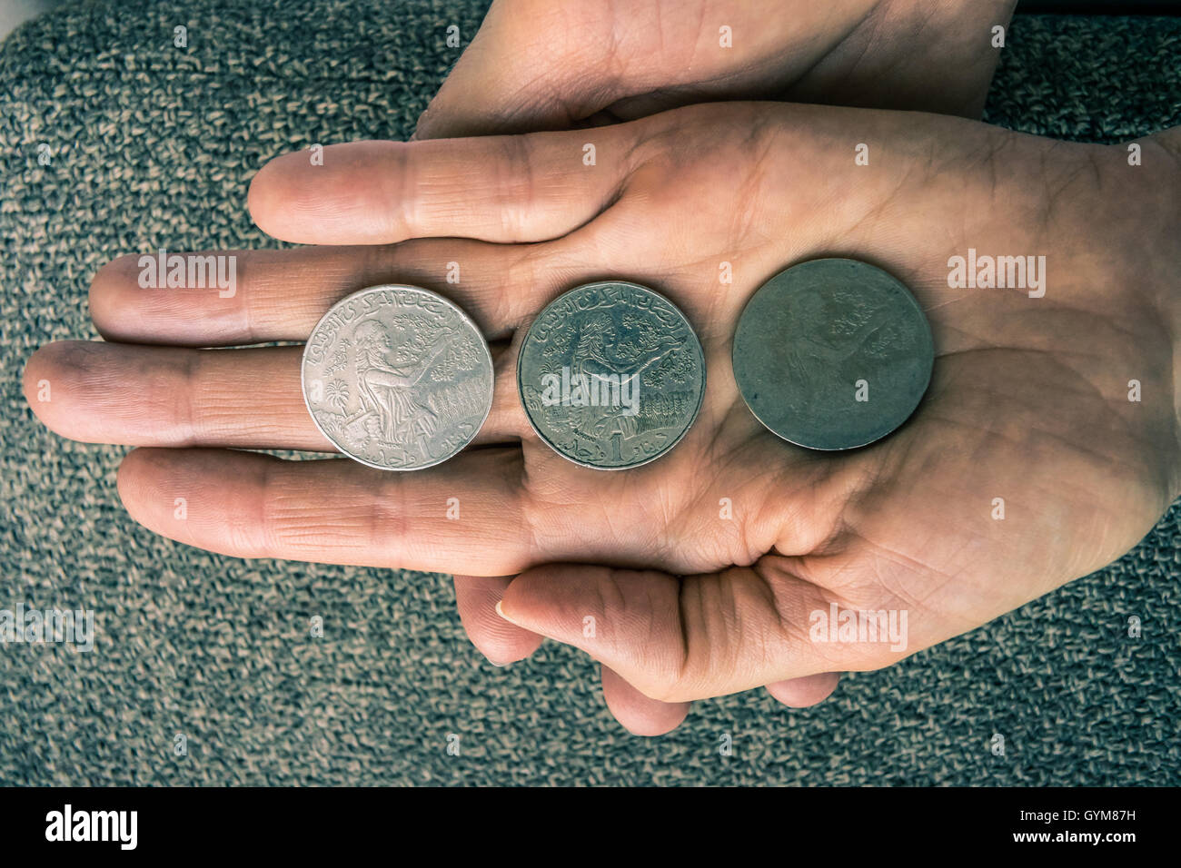 Three Tunisian coins on the woman's palm Stock Photo - Alamy