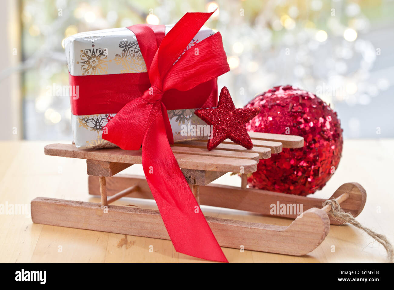 Little sledge with a gift box Stock Photo - Alamy