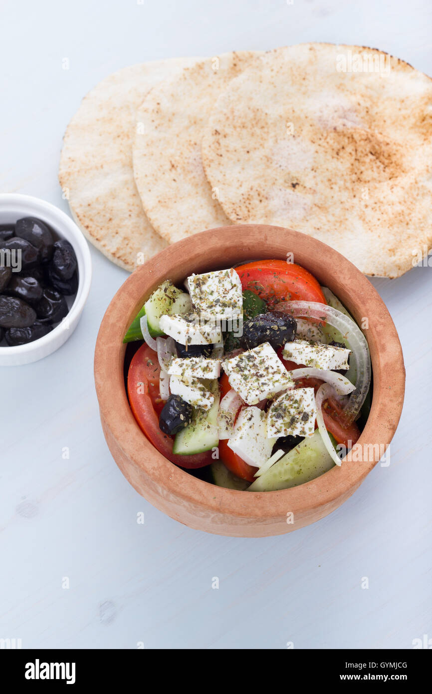 Greek salad in a clay pot with pitas and appetizers Stock Photo - Alamy