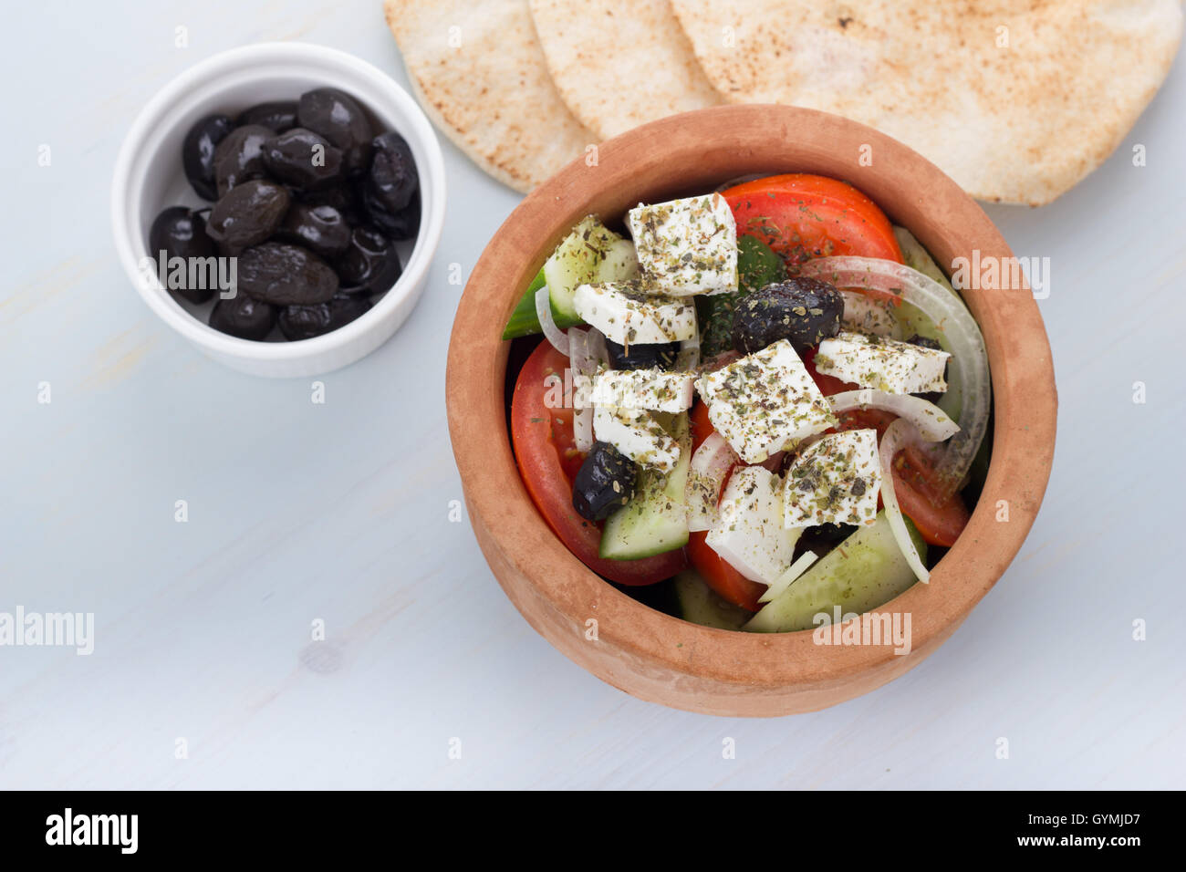 Greek salad in a clay pot with pitas and appetizers Stock Photo - Alamy