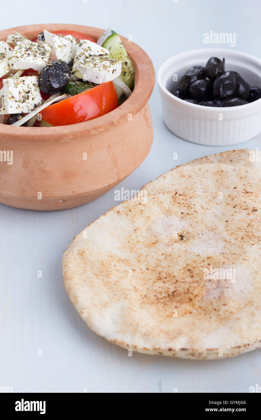 Greek salad in a clay pot with pitas and appetizers Stock Photo - Alamy