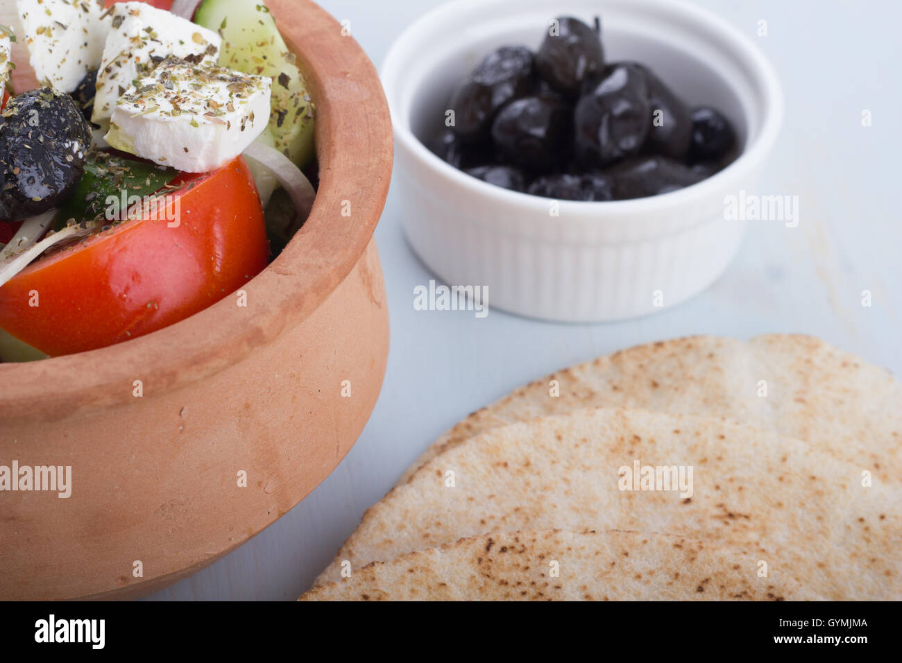 Greek salad in a clay pot with pitas and appetizers Stock Photo - Alamy