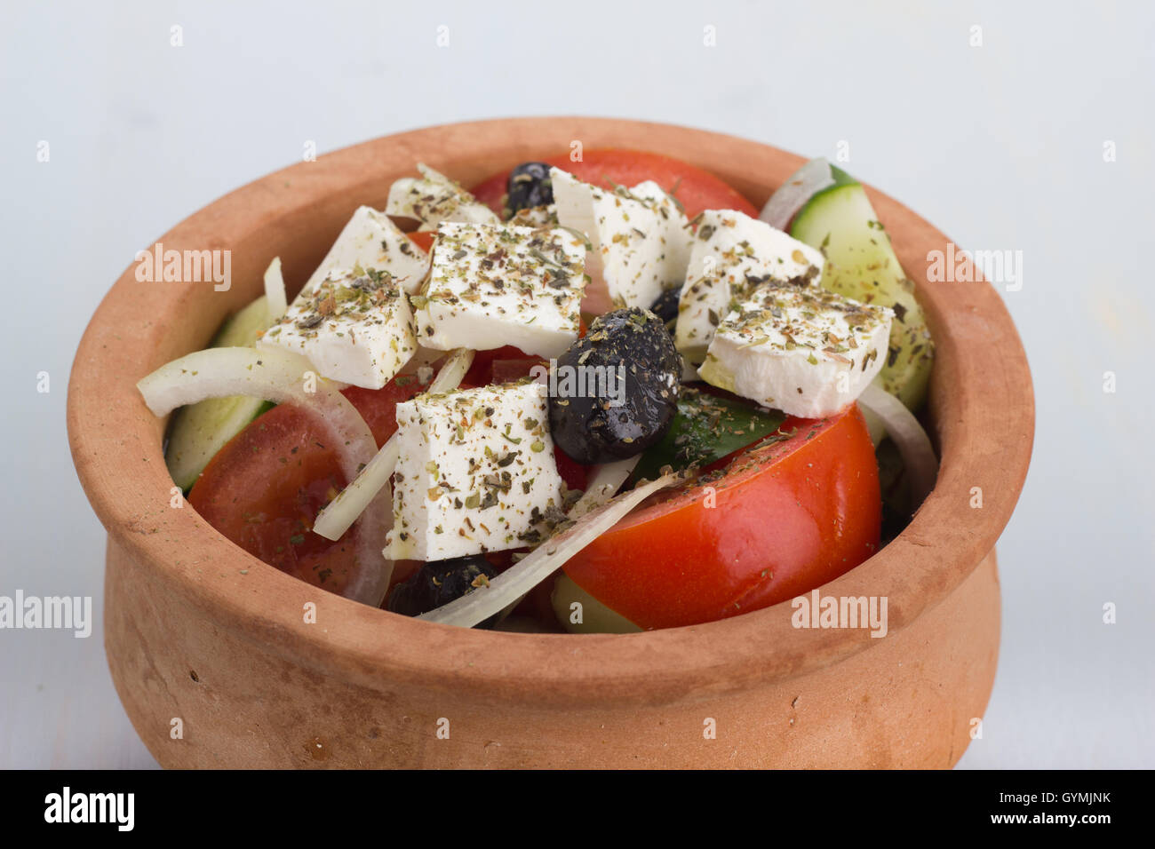 Greek salad in a clay pot with pitas and appetizers Stock Photo - Alamy
