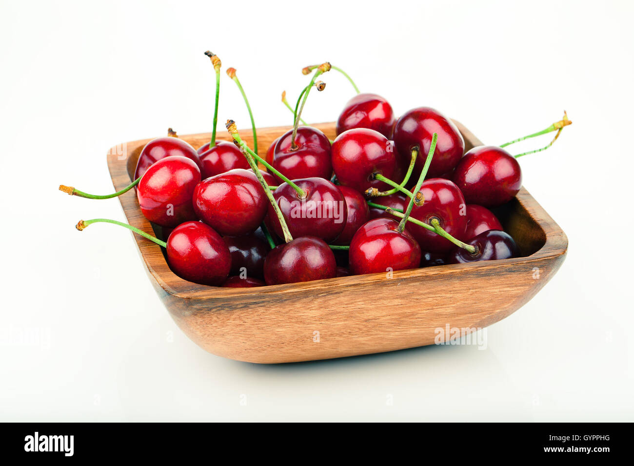 cherry berry in wooden bowl, isolated on white background Stock Photo ...