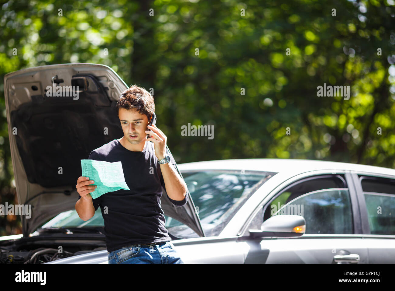 Handsome young man calling for assistance with his car broken Stock ...
